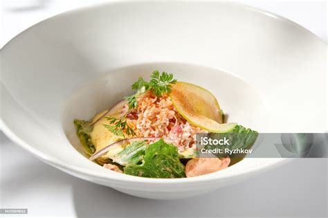 거친 그림자가있는 흰색 테이블에 게 고기 에스푸마 소스 및 양상추를 곁들인 우아한 샐러드 여름 메뉴에 게와 크림 소스를 곁들인 그린 샐러드 미적 음식 해산물 전채 갈고리