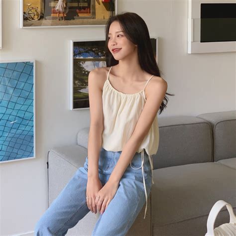 플라이모델 밑단의 스트랩 디테일로 다양한 연출이 가능한 슬리브리스 넥라인을 따라 은은하게 잡힌 셔링