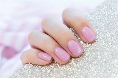 여자에 대 한 핑크 손톱을 닫습니다 세련 된 최신 유행 여성 손톱 매니큐어 핑크와 파란색 바탕에 아름 다운 젊은 여자의 손 상위 뷰 평평 하다입니다 텍스트 복사 공간 감정에