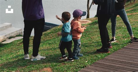 파란색 크루넥 티셔츠와 검은색 바지를 입은 남자가 주황색 티셔츠를 입은 소녀를 안고 있다 사진 Unsplash의 무료 햇빛 이미지