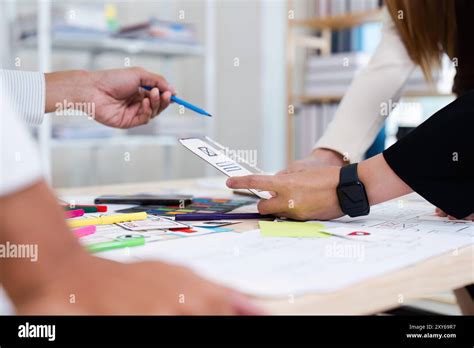 Creative Team Collaborating On Ux Ui Design Project With Wireframes And