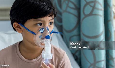 흡입기의 마스크에 의한 아픈 소년 흡입 요법 아기는 천식이 있고 분운이 필요합니다 환자 소년은 병원에서 분무기 마스크흡입을 사용합니다 아기는 기관지 확장제살을 하고 있습니다