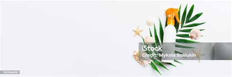 자외선 차단제 스프레이 병 태양 보호 크림과 색상 배경에 열대 녹색 잎이있는 바다 껍질이있는 병 상단 전망 0명에 대한 스톡