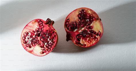 흰색 표면에 반으로 자른 석류 사진 Unsplash의 추상적인 이미지