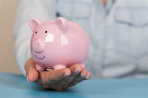 파란색 배경에 손에 돼지 저금통 텍스트 공간 금융 돈을 절약 은퇴 개념에 대한 성공과 저축을 위한 비즈니스 경제에 대한 스톡