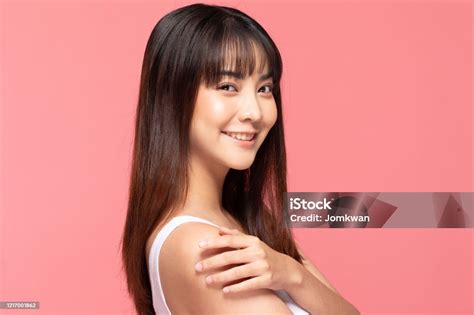 젊고 아름다운 아시아 여성은 깨끗하고 신선한 피부 행복과 긍정적 인 감정과 명랑 핑크 배경 뷰티 화장품 및 스파 트리트먼트