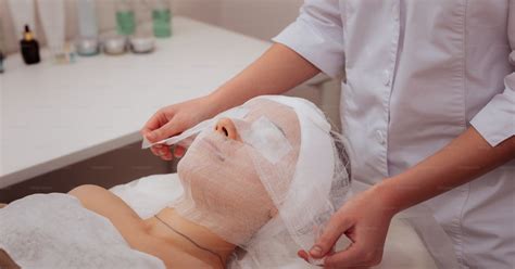 미용 클리닉 뷰티 클리닉에서 일하는 동안 고객의 얼굴에 붕대를 감는 멋진 유쾌한 여자 사진 Unsplash의 의료 및 의학 이미지