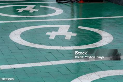 녹색 포장은 흰색 기호로 표시된 주차 공간을 특징으로 하며 이는 바쁜 도시 환경에서 특정 차량을 위한 지정된 영역을 나타냅니다 0명에 대한 스톡 사진 및 기타 이미지