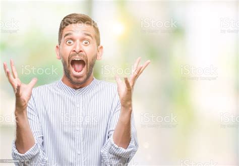 미친을 축 하 하 고 무기와 성공을 위한 흥분 비명 제기 및 오픈 눈 깜짝 놀라게 격리 된 배경 위에 젊은 잘생긴 남자 우승자 개념 긍정적인 감정 표현에 대한 스톡 사진 및