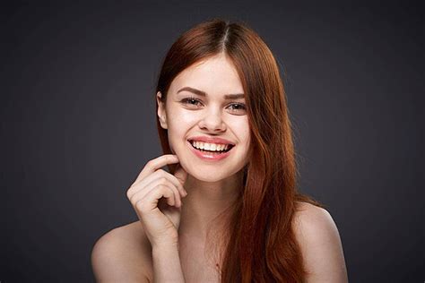 Stunning Redhead Exposing Bare Shoulders In Moody Backdrop Photo