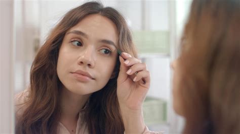 Premium Photo Beautiful Woman Plucking Eyebrows With Tweezers In Mirror At Bathroom
