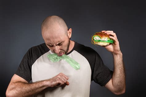 패스트 푸드와 생태의 개념 수염을 기르고 쓰레기를 채우고 햄버거를 채우고 질식한 대머리 남자 어두운 배경 복사 공간 Microplastic에 대한 스톡 사진 및 기타 이미지