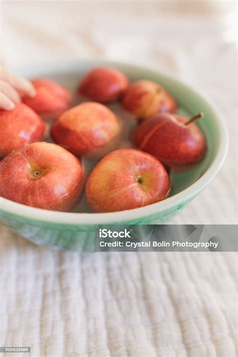 2022년 가을 동안 집에서 거지 크림 색 담요에 신선한 레드 갈라 사과를 바르고 물속에서 씻는 신선한 레드 갈라 사과로 가득 찬 청록색 빈티지 보로실리케이트 유리 그릇