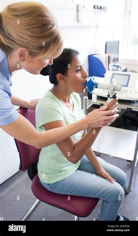 Lung Function Test Nurse Watching As A Patient Blows Into A Peak Flow