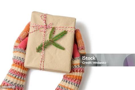 니트 장갑을 끼고 있는 여성의 손이 갈색 종이에 싸여 흰색 배경에 밧줄로 묶인 상자를 들고 있습니다 갈색에 대한 스톡 사진 및 기타 이미지 Istock