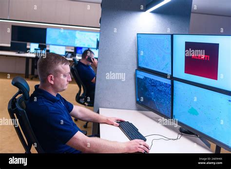 In The Security Control Room Officer Monitors Multiple Screens While Receiving The Alert Signal