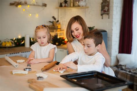 행복한 가족 엄마와 두 아이는 크리스마스 쿠키를 만들고 부엌에서 집에서 함께 즐거운 시간을 보냅니다 수제 크리스마스 진저 브레드를 만드는 어린이 형제 자매 12월에 대한