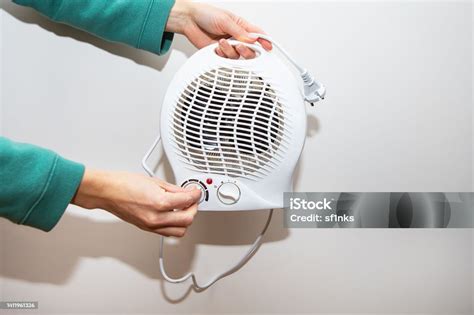흰색 배경에 고립 된 히터 한 소녀가 플라스틱 팬 히터를 들고 온도 조절기를 보여줍니다 계절에 대한 스톡 사진 및 기타 이미지 계절 공기 주입 기후 묘사 Istock