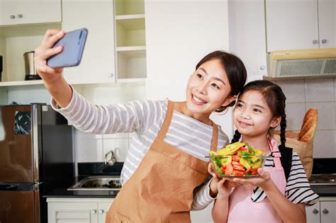 어머니와 소녀는 샐러드를 준비하고 소셜 미디어를 위해 스마트 폰으로 셀카를 찍습니다 레저 활동 10 11세에 대한 스톡 사진 및 기타 이미지 Istock