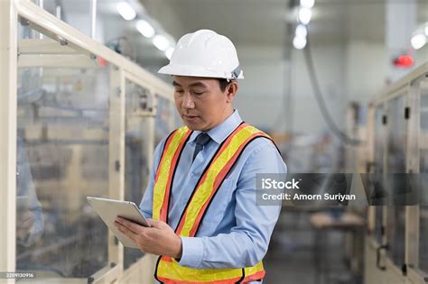 남성 엔지니어 산업 공장 보관 창고 산업 공장에서 디지털 태블릿 제어 또는 생산 시스템 작동 확인 작업을 수행하는 아시아 남성 공장 엔지니어 45 49세에 대한 스톡 사진