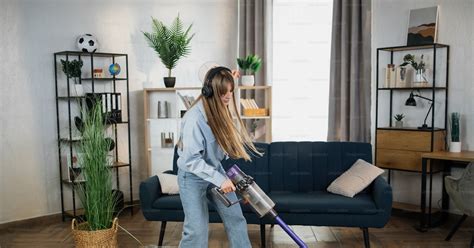 현대적인 헤드폰을 쓴 매력적인 젊은 여성이 휴대용 진공 청소기로 집을 청소하면서 좋아하는 음악을 즐기고 있다 개념 집안일 사진 Unsplash의 현대 거실 이미지