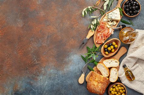 검은 색과 녹색 올리브 올리브 나무 가지 오일 치즈 도르블루 또는 고르곤졸라 프로슈토와 시아바타 빵 어두운 테이블에 맨 위 보기 플랫 레이 건강한 식생활에 대한 스톡 사진