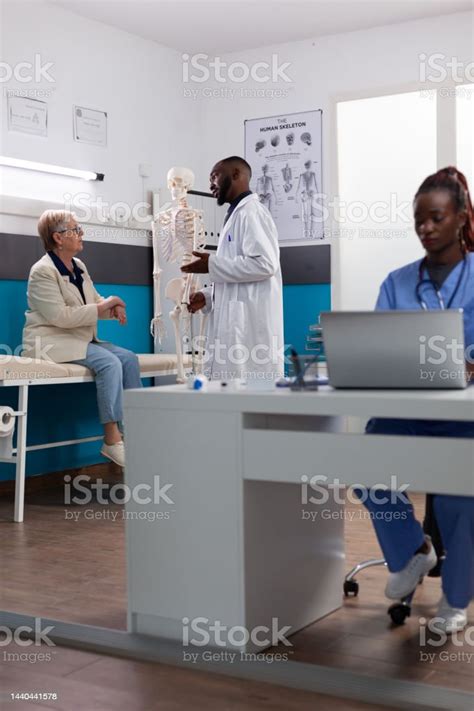 뼈 질환을 설명하는 인간의 골격 팔을 보여주는 전문 물리 치료사 남자 3 명에 대한 스톡 사진 및 기타 이미지 3 명 간호사 건강관리와 의술 Istock