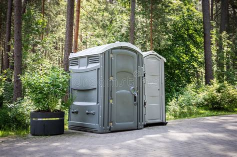 Portable Toilets In Forest Park Setting For Outdoor Events Or Public
