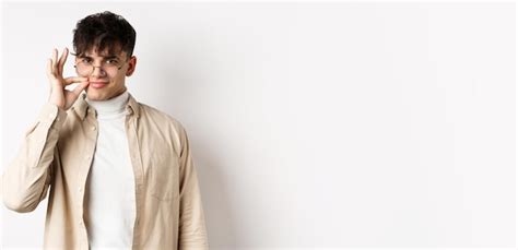 안경에 웃는 교활한 남자는 입술 근처에 인감 제스처를 보여주는 지퍼에 입을 다물고 D 미소 무료 사진