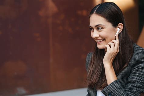 도시의 일몰에 무선 헤드폰을 사용하여 휴대 전화로 화상 통화를하는 젊은 웃는 사업가 공간을 복사합니다 온라인 커뮤니케이션 개념
