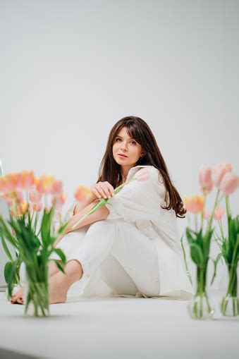 흰색의 부드러운 갈색 머리는 튤립 꽃병과 함께 바닥에 앉아 있습니다 3월에 대한 스톡 사진 및 기타 이미지 3월 가정 생활 갈색 머리 Istock