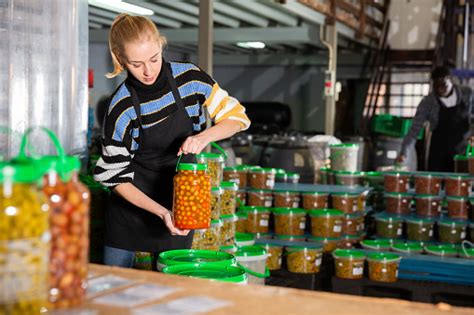 คนงานหญิงสต็อกภาชนะพลาสติกและถังขยะที่มีมะกอกในคลังสินค้า ภาพสต็อก ดาวน์โหลดรูปภาพตอนนี้ Istock