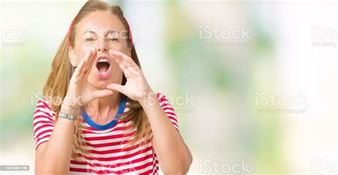 아름 다운 중 년 여성 캐주얼 입고 입을 통해 소리로 손으로 성 난 소리 고립 된 배경 위에 T셔츠 줄무늬 T 셔츠에 대한 스톡 사진 및 기타 이미지 Istock