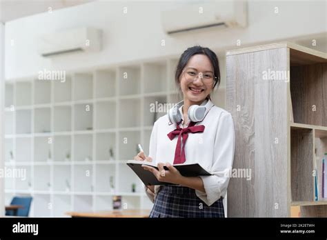 Young Female Student Doing Assignments In Library Asian Woman Taking