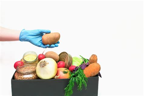 야채 시리얼 캔 계란 및 과일이 담긴 음식 도움말 상자를 제공합니다 복사 공간이 격리된 코로나바이러스 배달 자선 단체를 위한 기부 제품으로 보호용 의료용 손 장갑을 착용하고