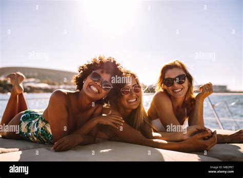 Group Of Beautiful Women Relaxing On A Yacht Deck Three Female Friends Sunbathing On Small Boat
