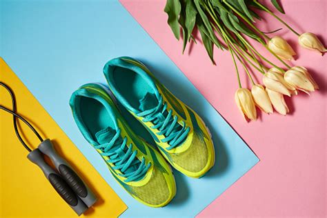 화려한 파스텔 배경에 스포츠 신발 밧줄과 튤립 꽃다발을 건너 뛰는 쌍 분홍색 파란색 및 노란색 종이에 새로운 스니커즈 복사 공간 러닝 풋 웨어의 오버헤드 샷 상단 보기 플랫