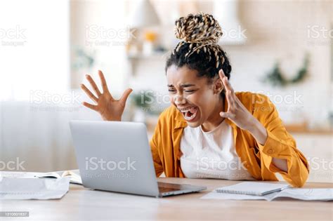 피곤 한 좌절 충격 젊은 아프리카 계 미국인 여자 캐주얼 옷 관리자 또는 프리랜서 노트북에서 작업 나쁜 비즈니스 보고서를 얻었다 과로 자극 그녀의 손으로 몸짓 25 29세에