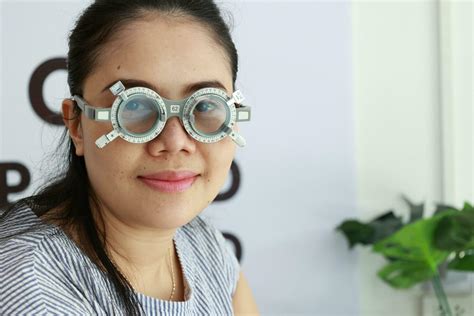 Eye Exam Concept Woman Eye Test In Clinic Beautiful Girl Wearing Eyeglass On Blur Optical Shop