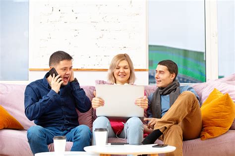 친구는 채팅 및 스마트 폰 데스크톱 컴퓨터 노트북을 사용 하 여 소파에 앉아 있다 공동체에 대한 스톡 사진 및 기타 이미지 공동체 공유 개념 동슬라브족 Istock