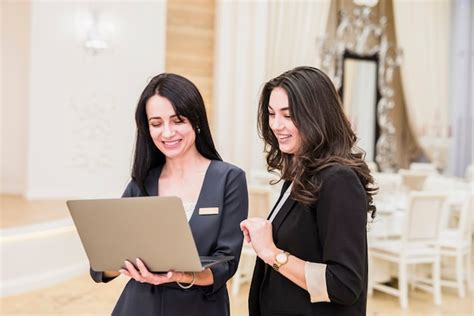 Free Photo Event Manager Showing Laptop To Happy Woman