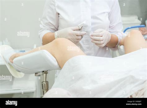 Gynecologist With Forceps Examining Female Patient On Gynecological Chair Holding Forceps Stock