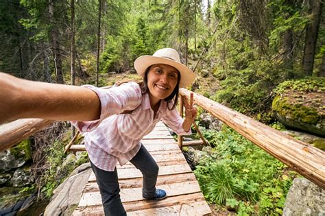 자연 셀카로 돌아가기 솔로 여행자 고대 나무 다리를 발견 자연에서 걷는 행복한 젊은 여성 관광객 화창한 날에 야외에서 즐기는 즐거움 건강한 생활방식에 대한 스톡 사진 및