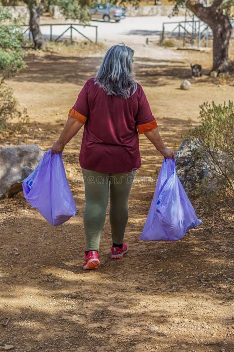 Woman On Her Back With Garbage Bags Collected In The Field Stock Image