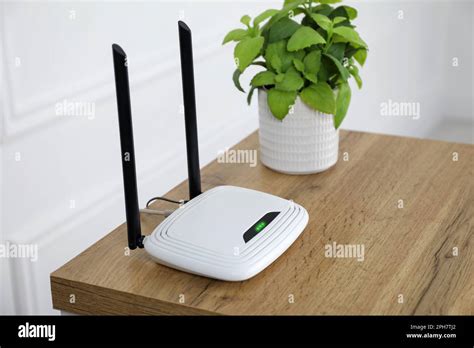 Wi Fi Router And Houseplant On Wooden Table In Room Stock Photo Alamy