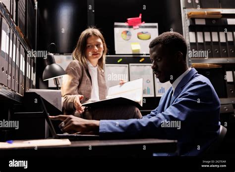 Police Officers Analyzing Criminology Report Working Overtime At