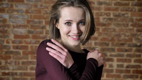 Young Beautiful Shy Girl Is Watching At Camera Smiling Watching Down