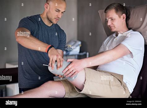 lets take a closer look a physiotherapist examining a man with an