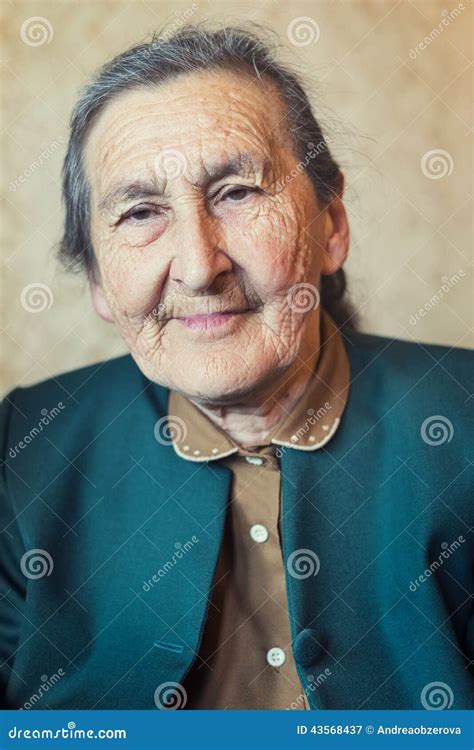 Добавочная годовалая старшая женщина красивые 80 представляя для портрета в ее доме Стоковое