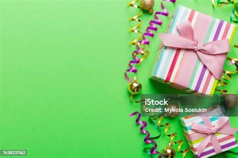 วันหยุดแบนวางกับกล่องของขวัญห่อด้วยกระดาษที่มีสีสันและผูกตกแต่งด้วยกระดาษโปรยบนพื้นหล ภาพสต็อก